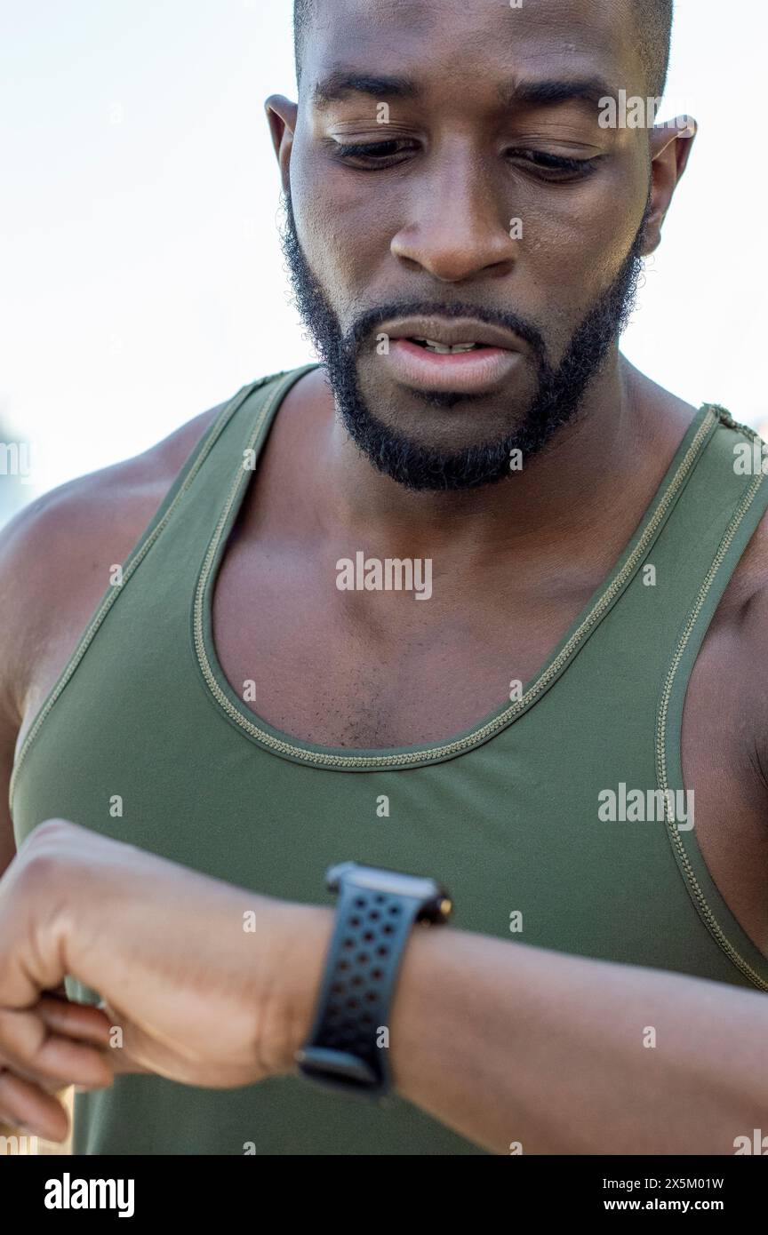Mid adult man looking at wristwatch Stock Photo - Alamy