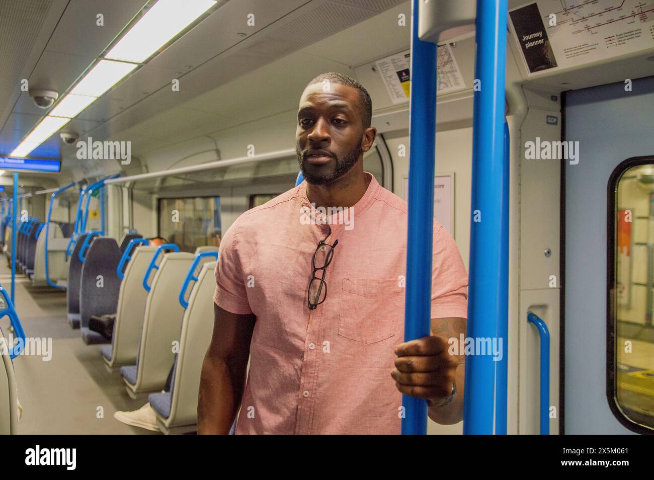 Man holding rail while standing in passenger train Stock Photo - Alamy
