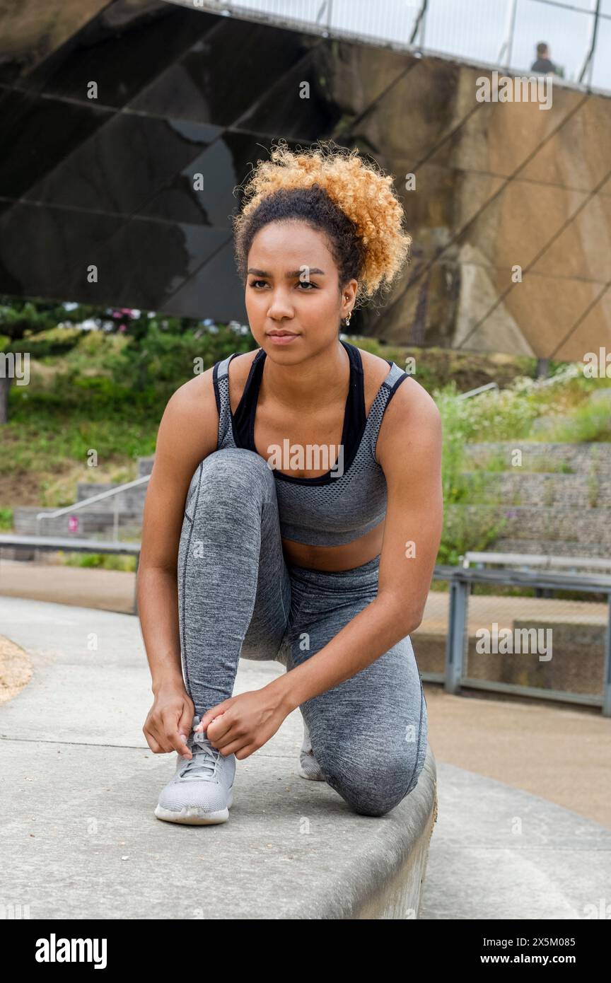 Woman tying shoelace hi-res stock photography and images - Alamy