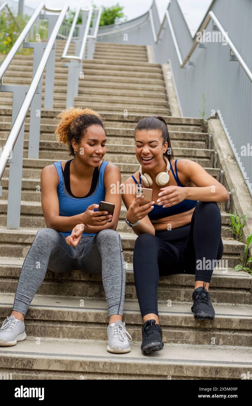 Sporty female friends using phones Stock Photo - Alamy