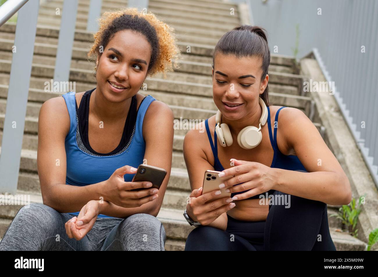 Three female friends using phones hi-res stock photography and images - Alamy