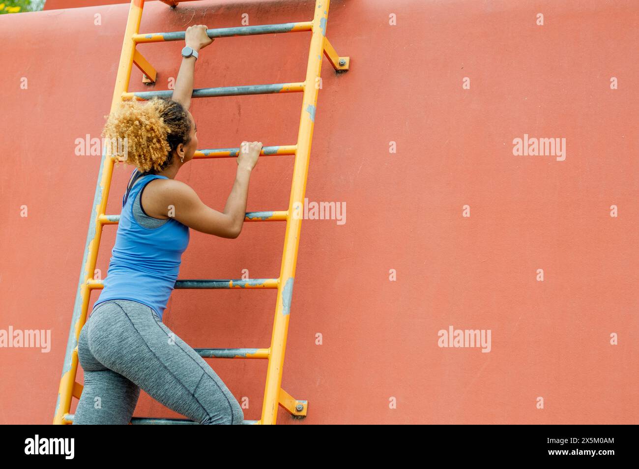 Woman climbing ladder hi-res stock photography and images - Alamy