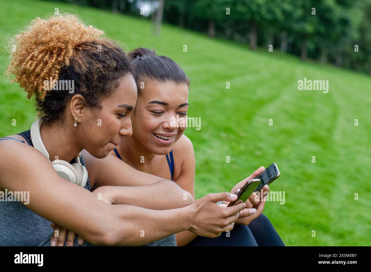 Female friends using phones Stock Photo - Alamy