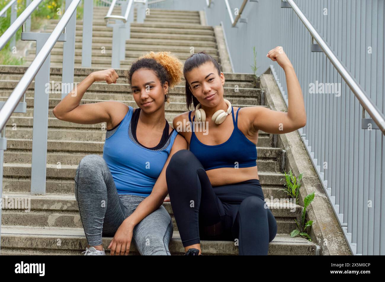 Portrait of female friends flexing biceps Stock Photo - Alamy