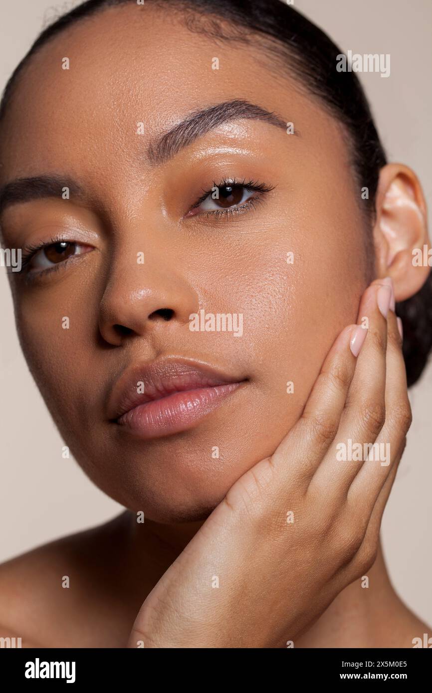 Portrait of young woman touching face Stock Photo - Alamy