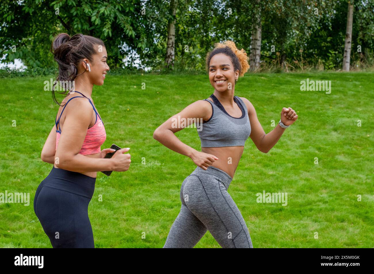 Two happy women jogging together Stock Photo - Alamy