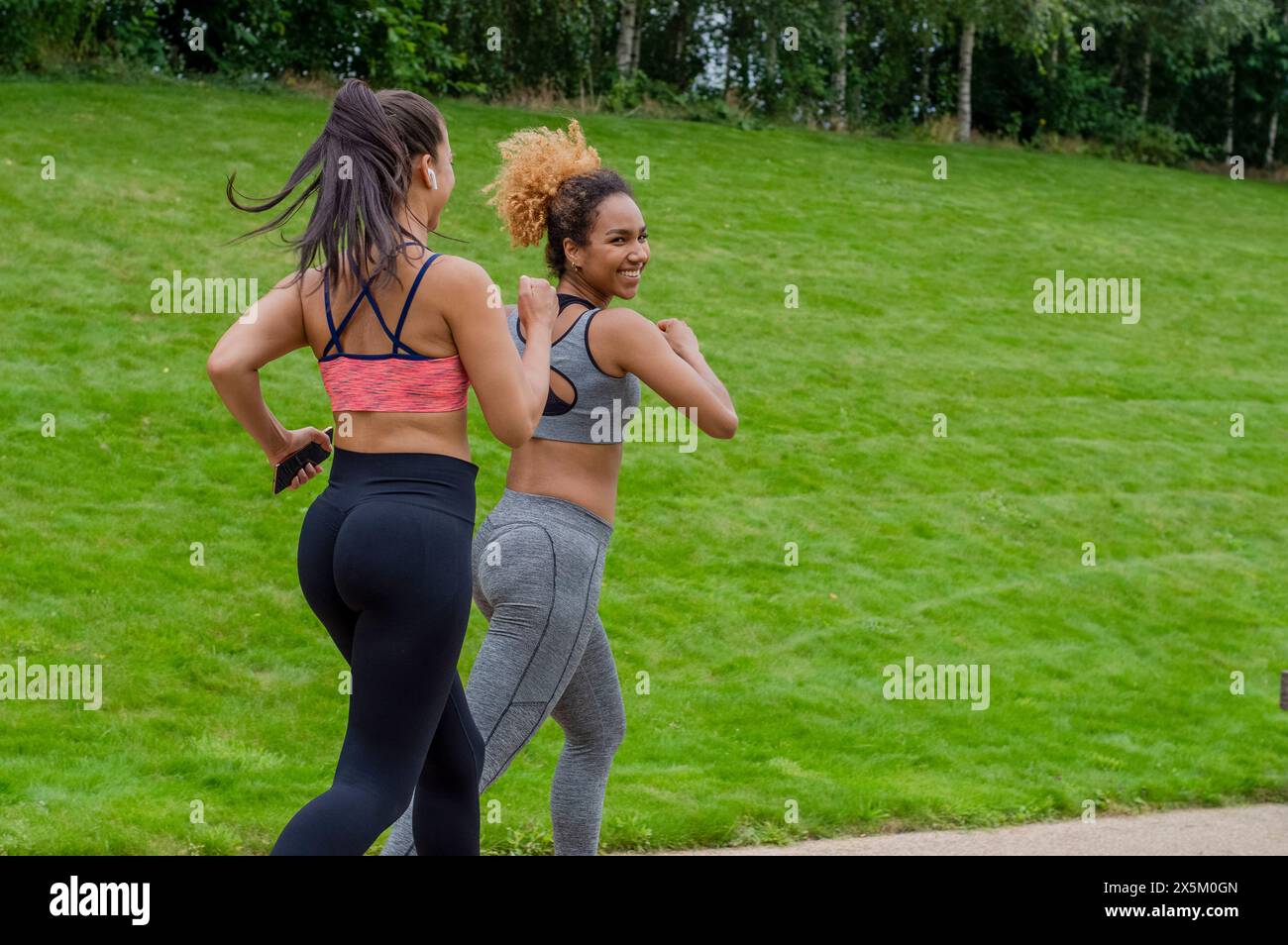 Two happy women jogging together Stock Photo - Alamy