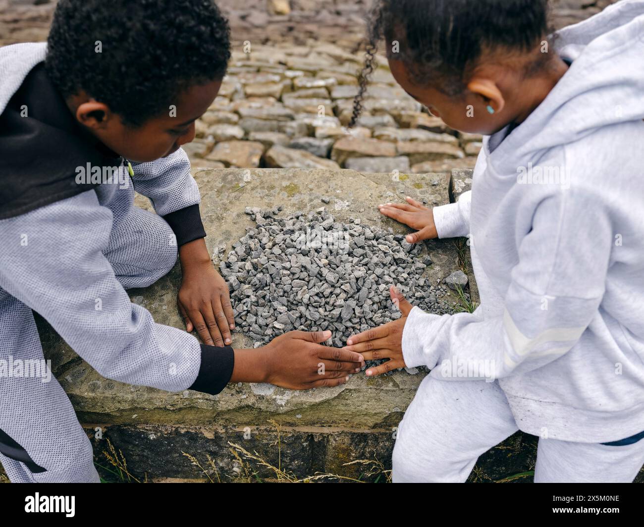 Brother and sister collecting rocks Stock Photo - Alamy