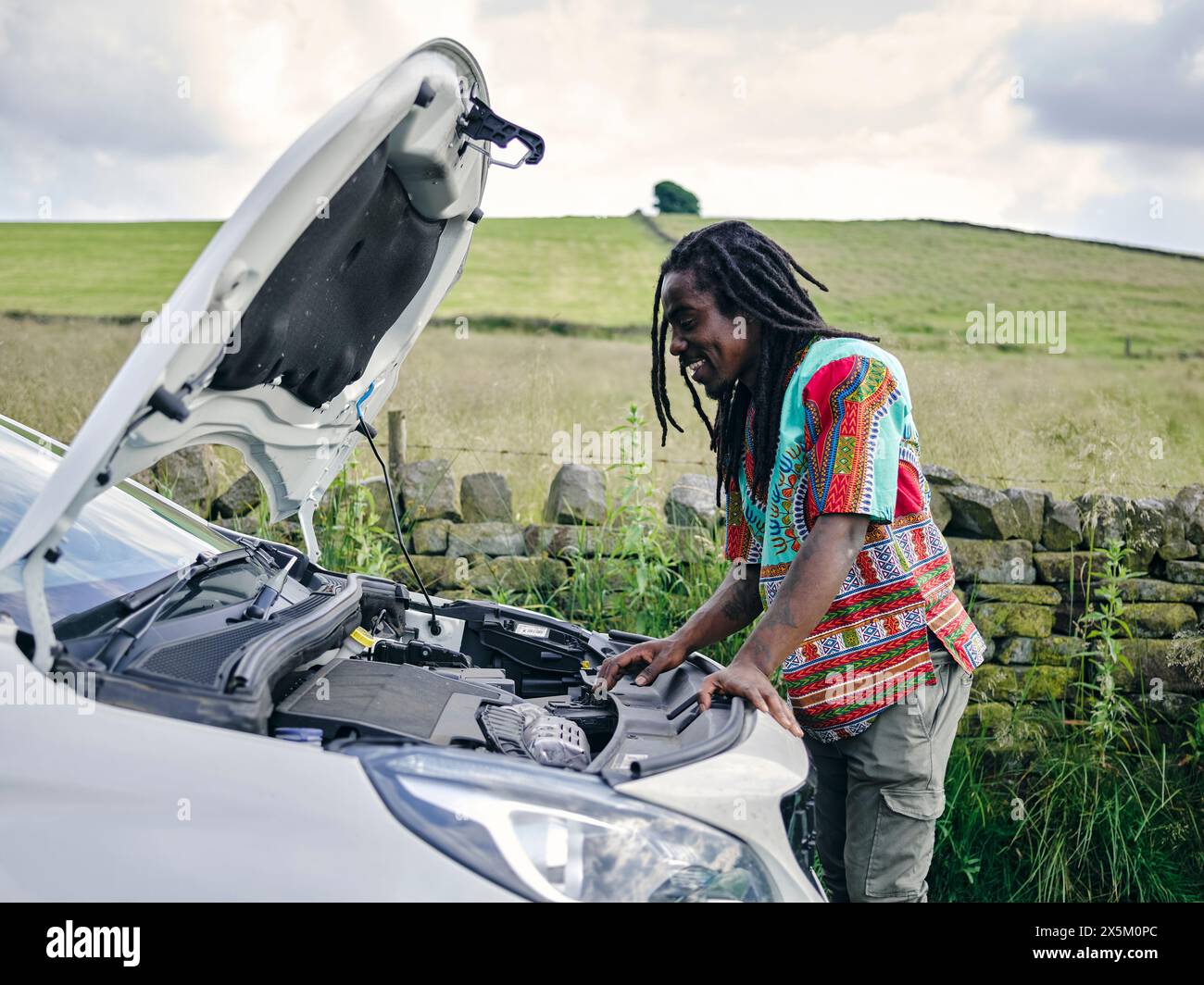 Man fixing car on roadside Stock Photo - Alamy