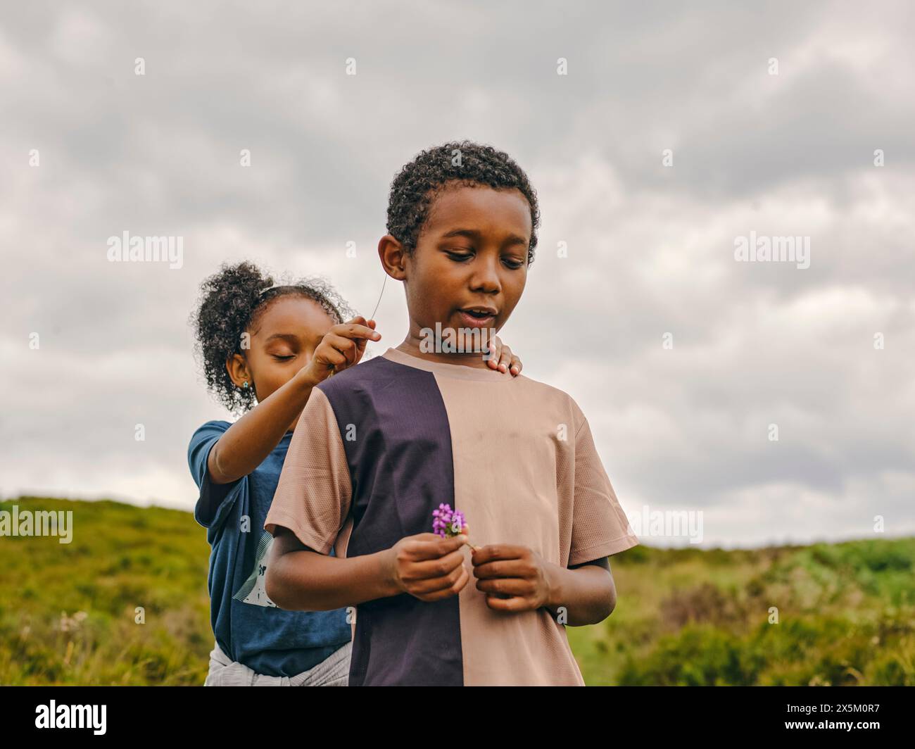 Sister standing behind brother Stock Photo - Alamy