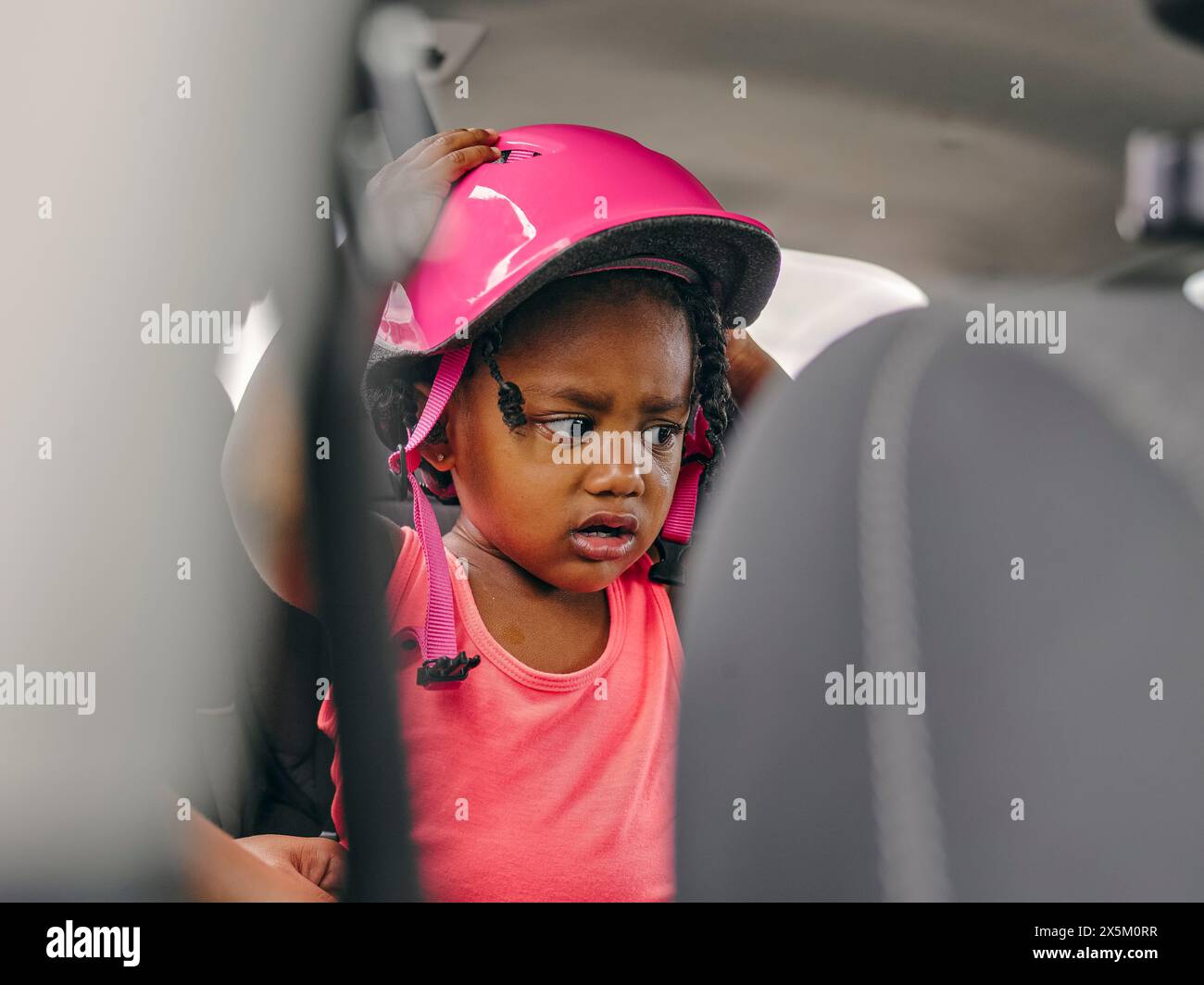 Girl wearing safety helmet in car Stock Photo - Alamy