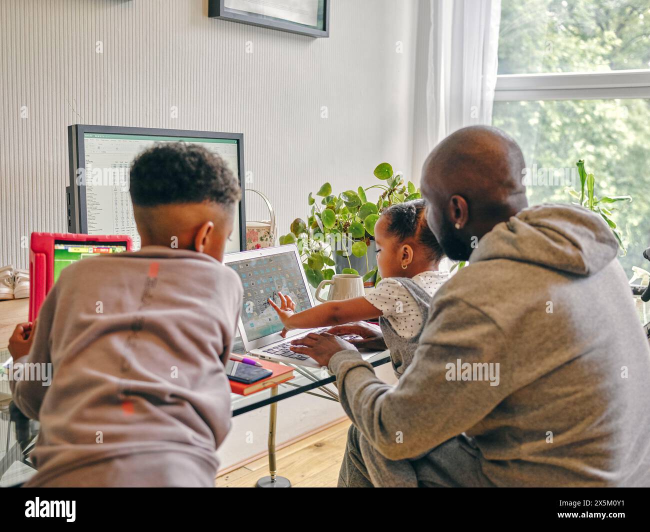 Father with son and daughter using computer at home Stock Photo - Alamy
