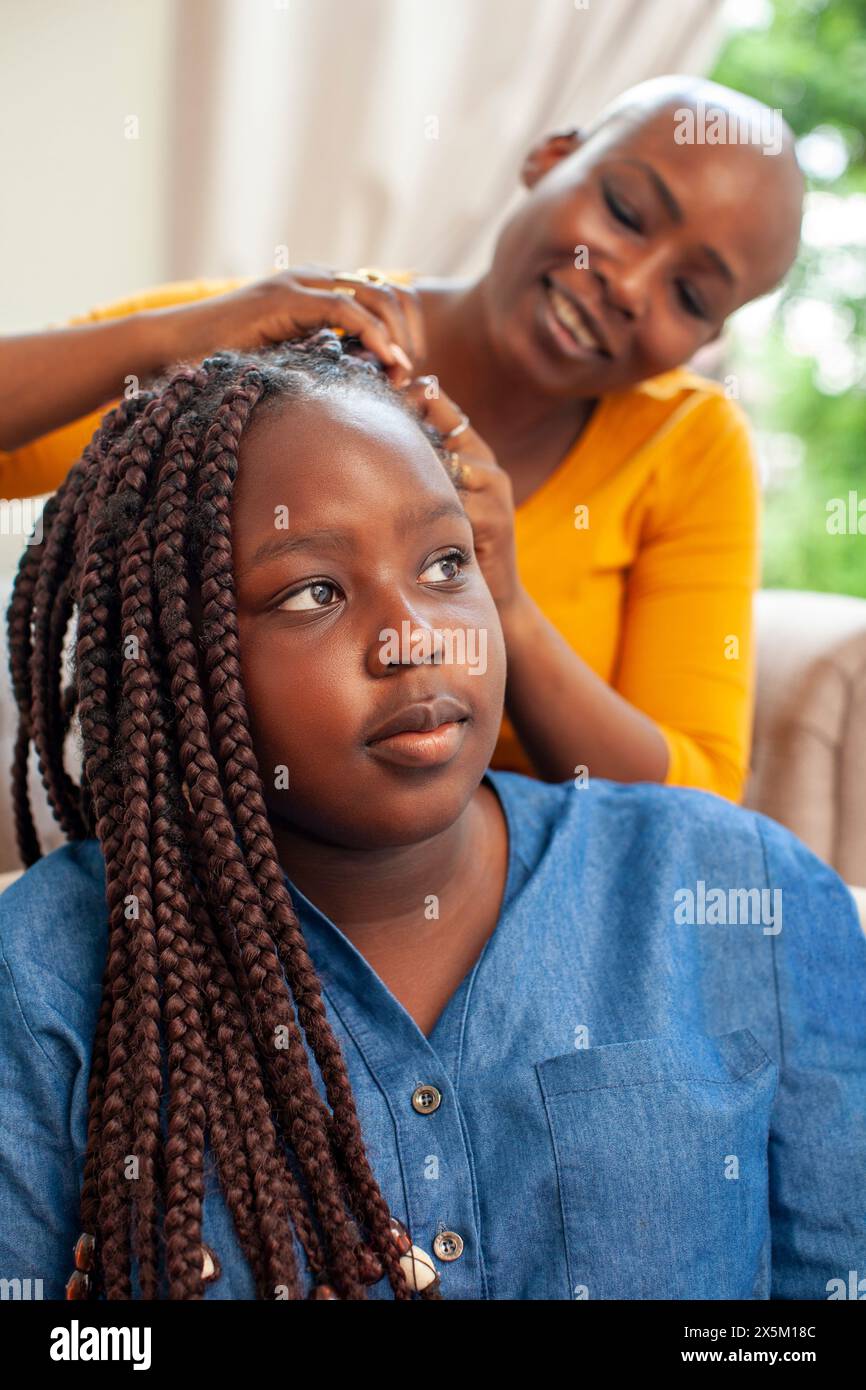 Mother braiding hair for daughter Stock Photo - Alamy