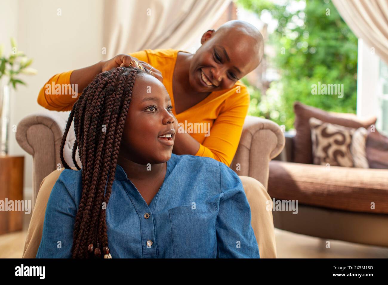 Mother braiding hair for daughter Stock Photo - Alamy