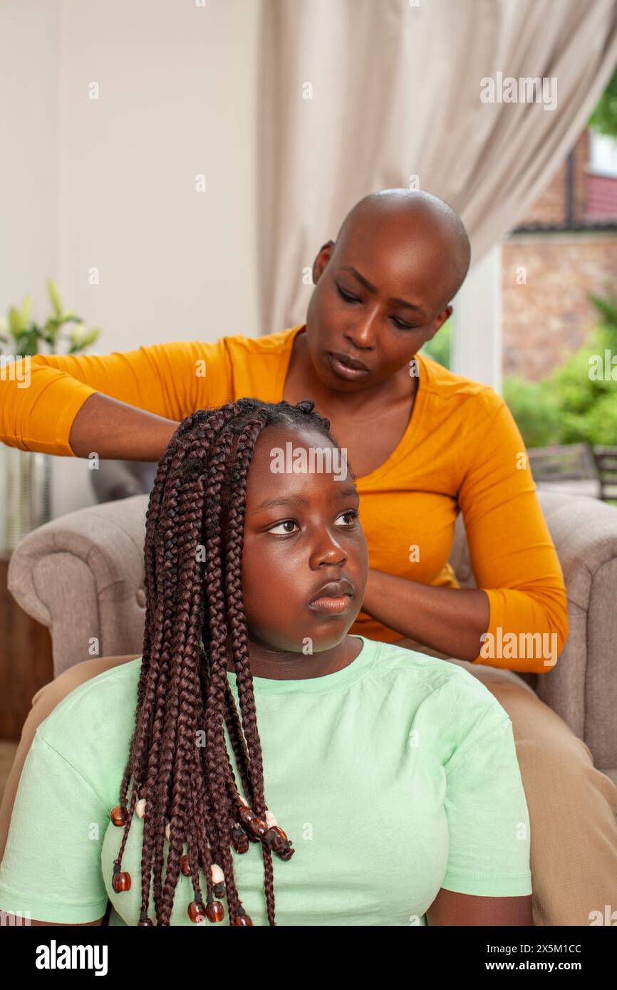 Mother braiding hair for daughter Stock Photo - Alamy