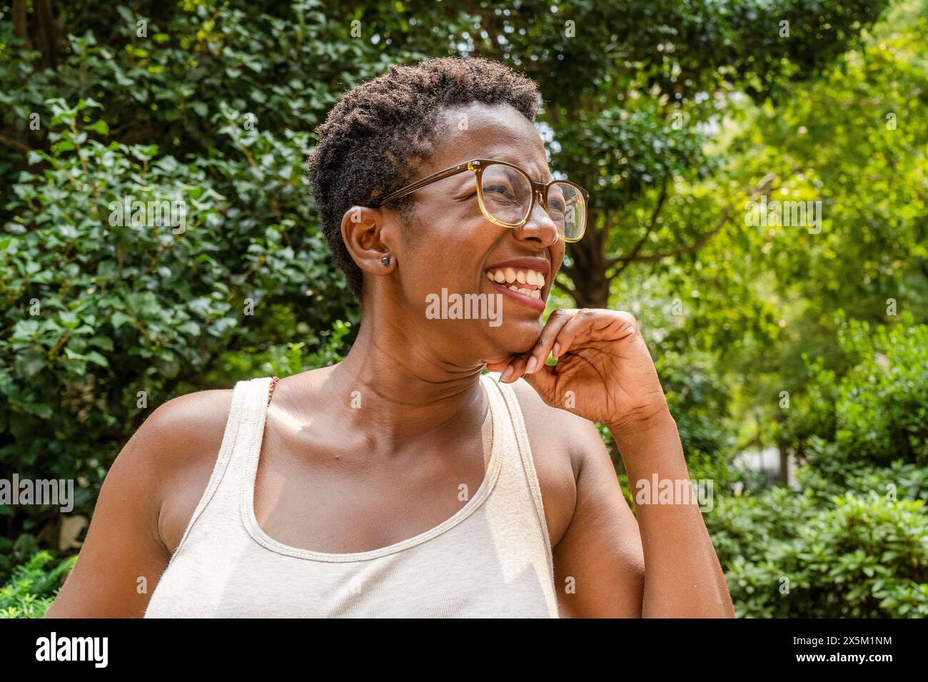 USA, Young woman in tank top smiling outdoors Stock Photo - Alamy