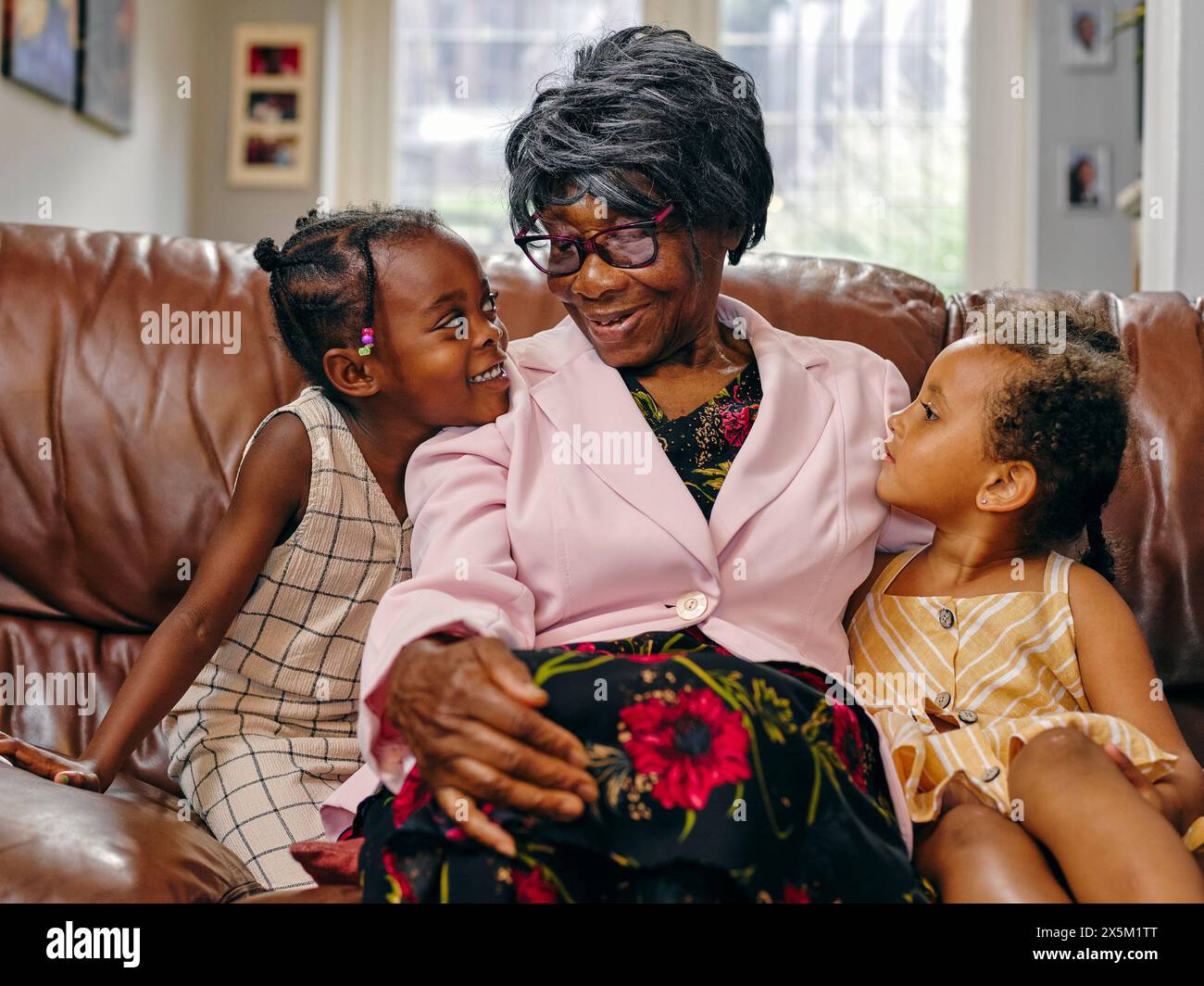 Great grandmother sitting on sofa with great granddaughters Stock Photo ...