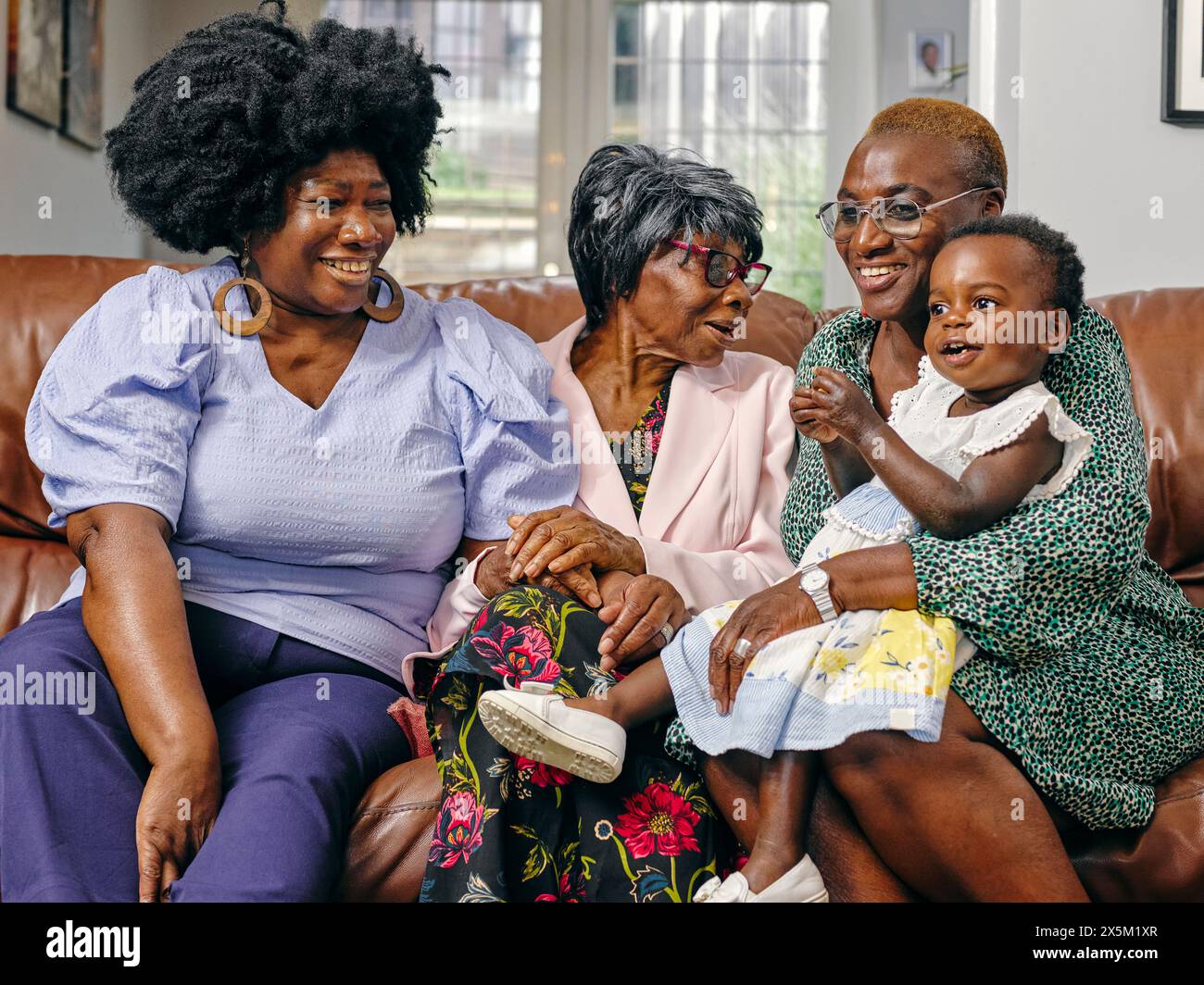 Mature women sitting on sofa with senior mother and baby girl Stock ...