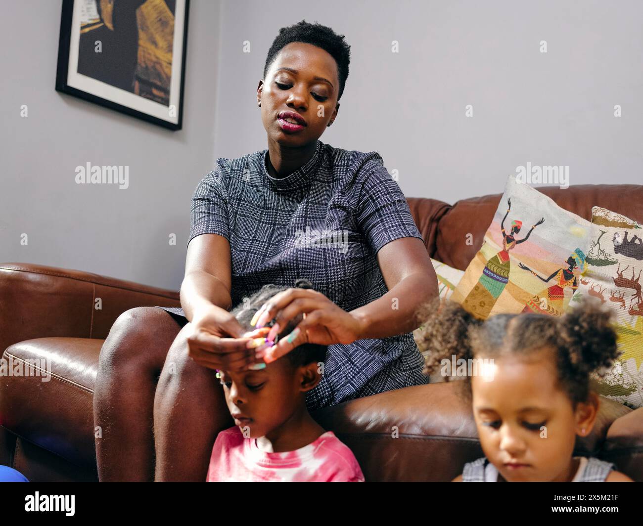 Mother braiding daughters hair Stock Photo - Alamy