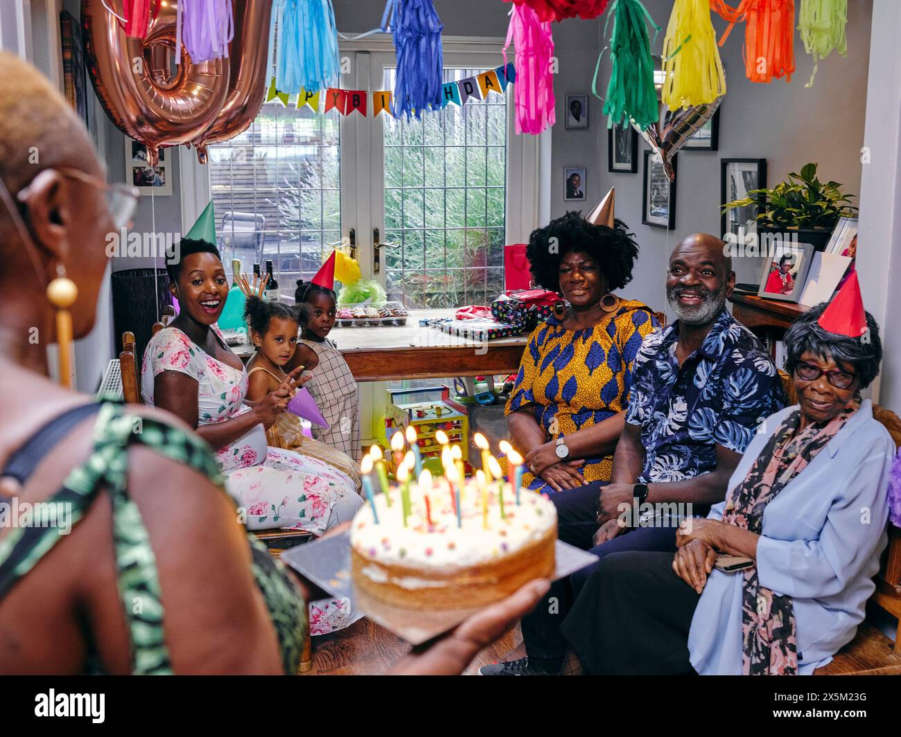 Multi-generation family celebrating birthday with birthday cake Stock ...