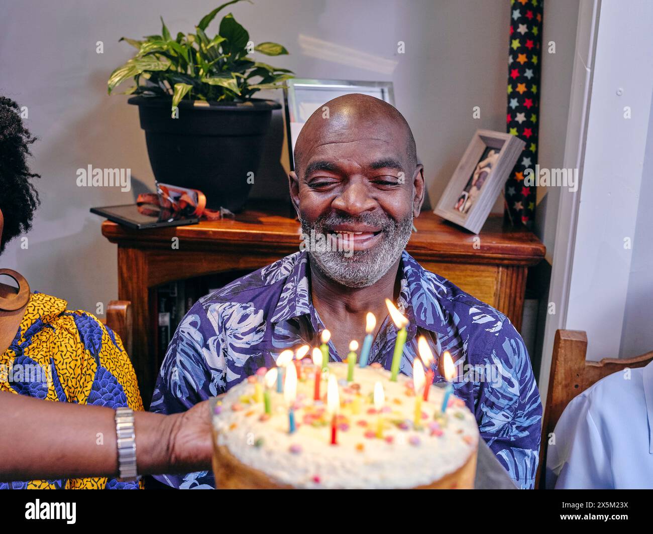 Smiling man looking at birthday cake Stock Photo - Alamy