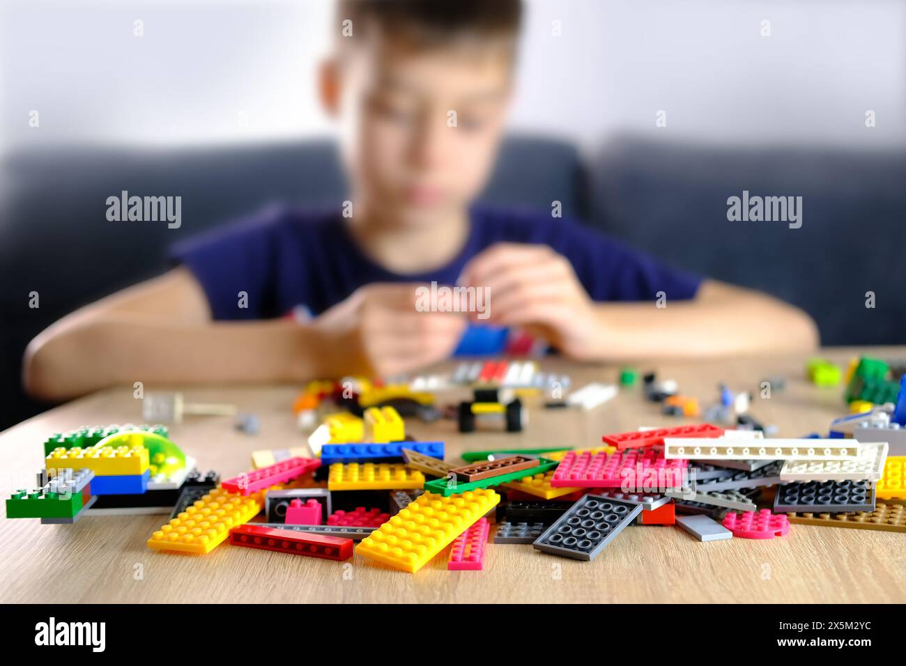 child, kid plays with colored plastic parts of the constructor, creates ...