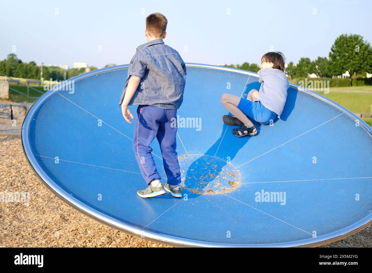 two boys, children 9-10 years play in playground, try to keep balance ...