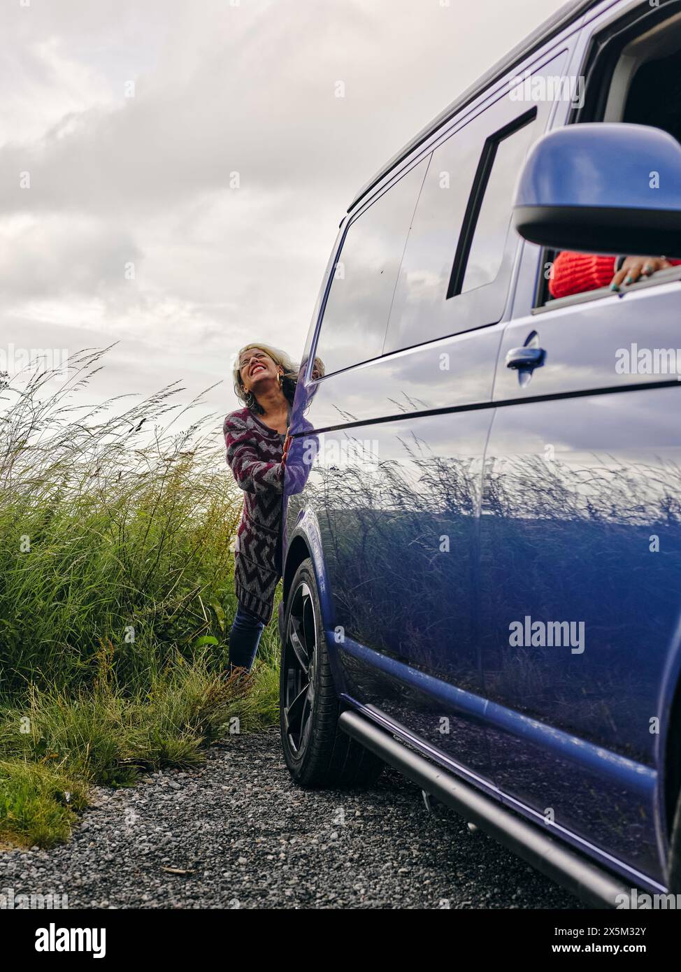 Woman pushing broken van Stock Photo - Alamy