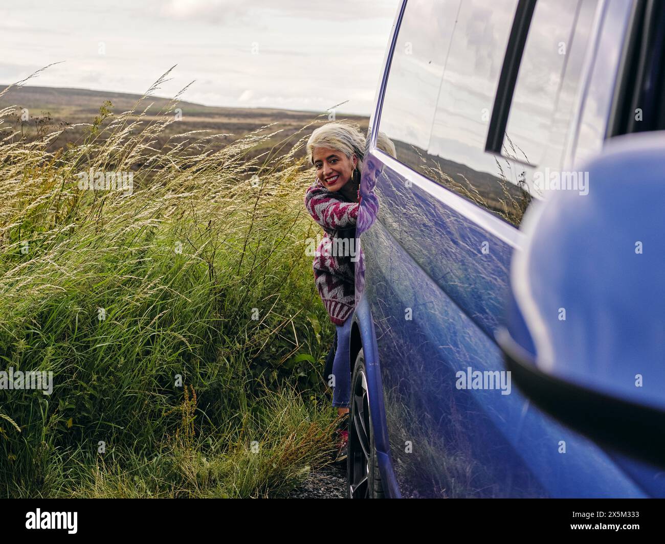 Woman pushing broken van Stock Photo - Alamy