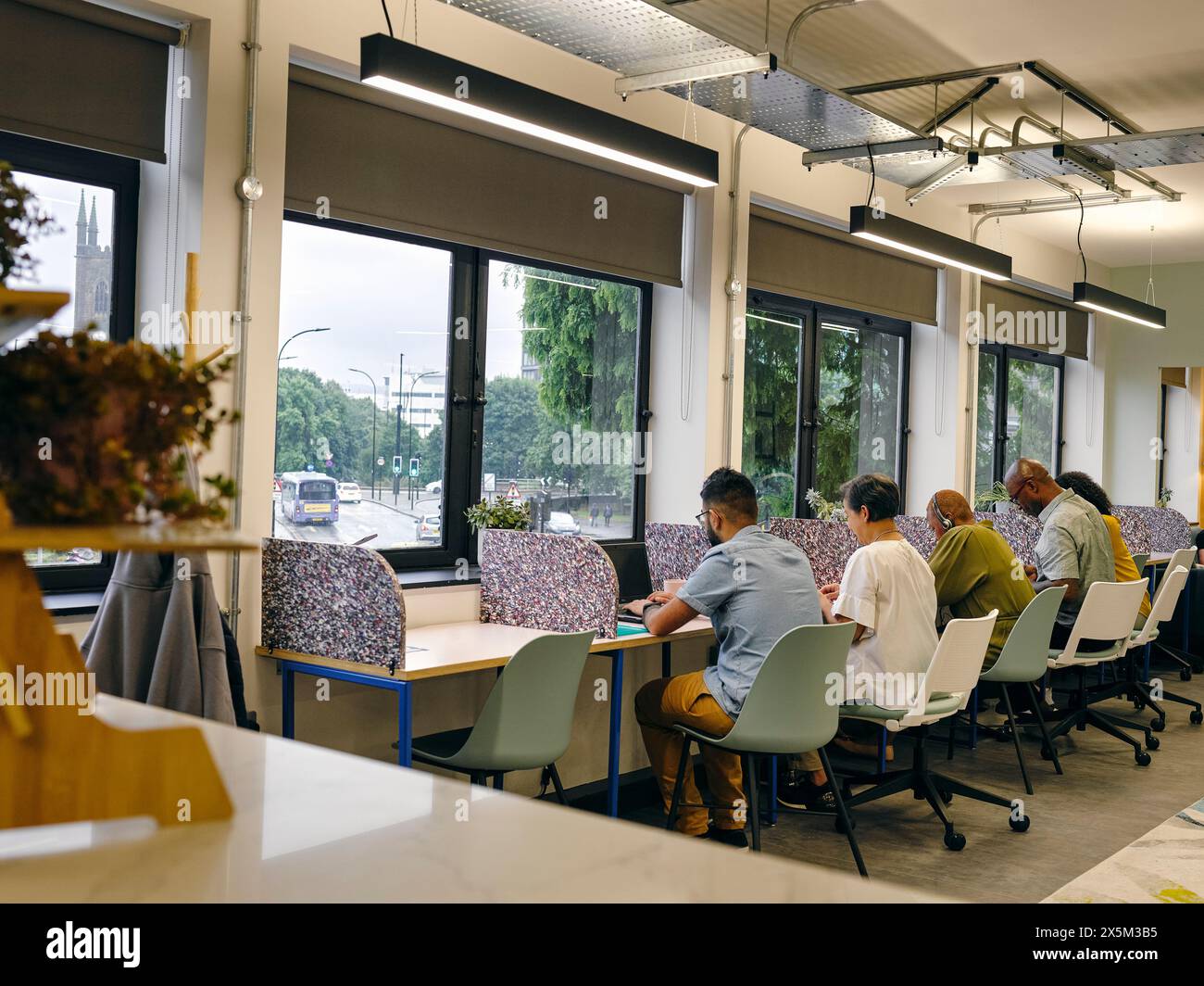 People working on laptops in office space Stock Photo - Alamy