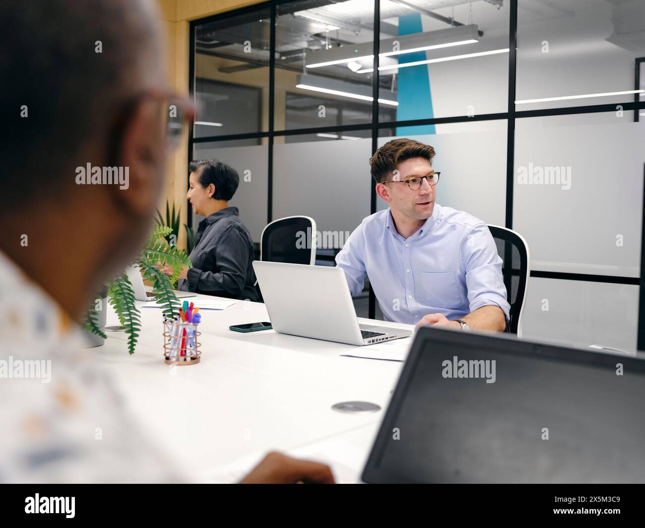 Office workers using computers in co-working office space Stock Photo ...