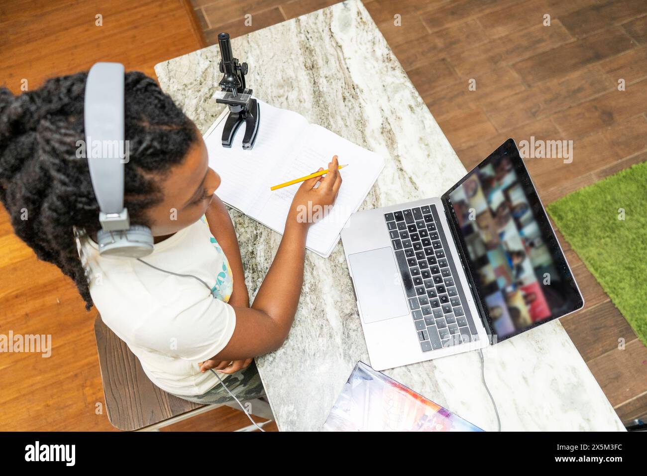 Girl using laptop to do homework Stock Photo - Alamy