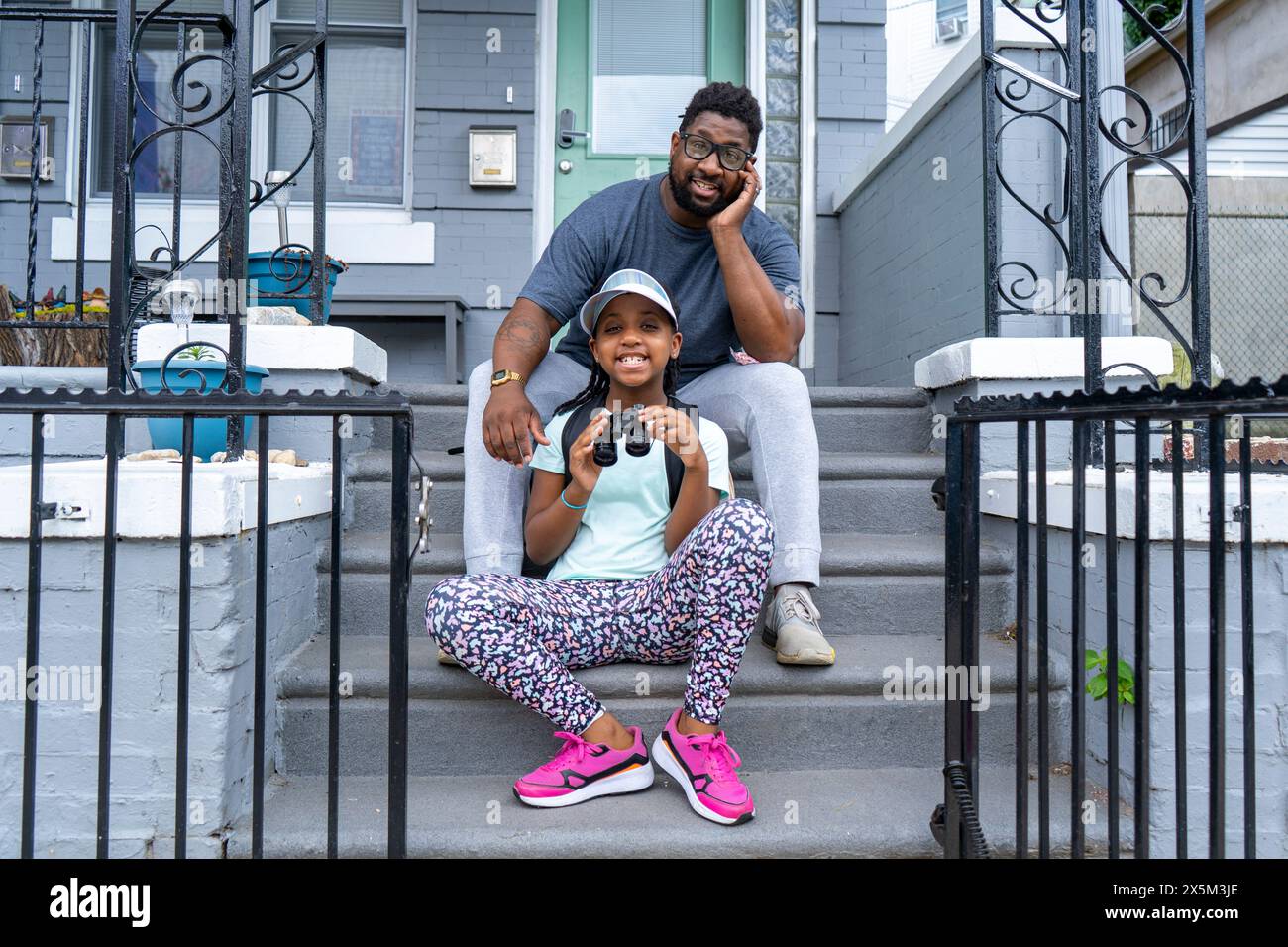 Portrait of father and daughter sitting on porch Stock Photo - Alamy