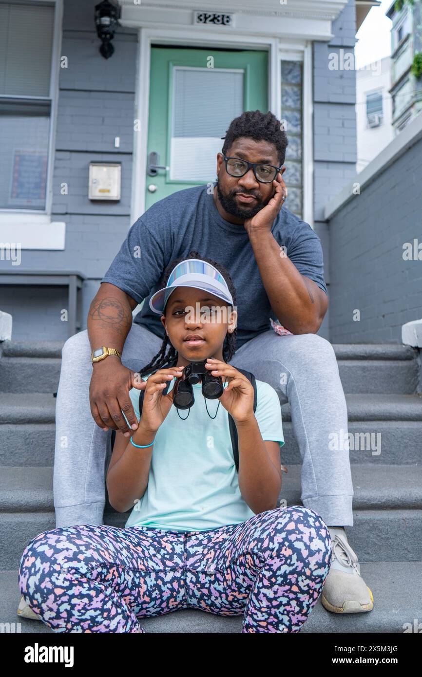 Portrait of father and daughter sitting on porch Stock Photo - Alamy