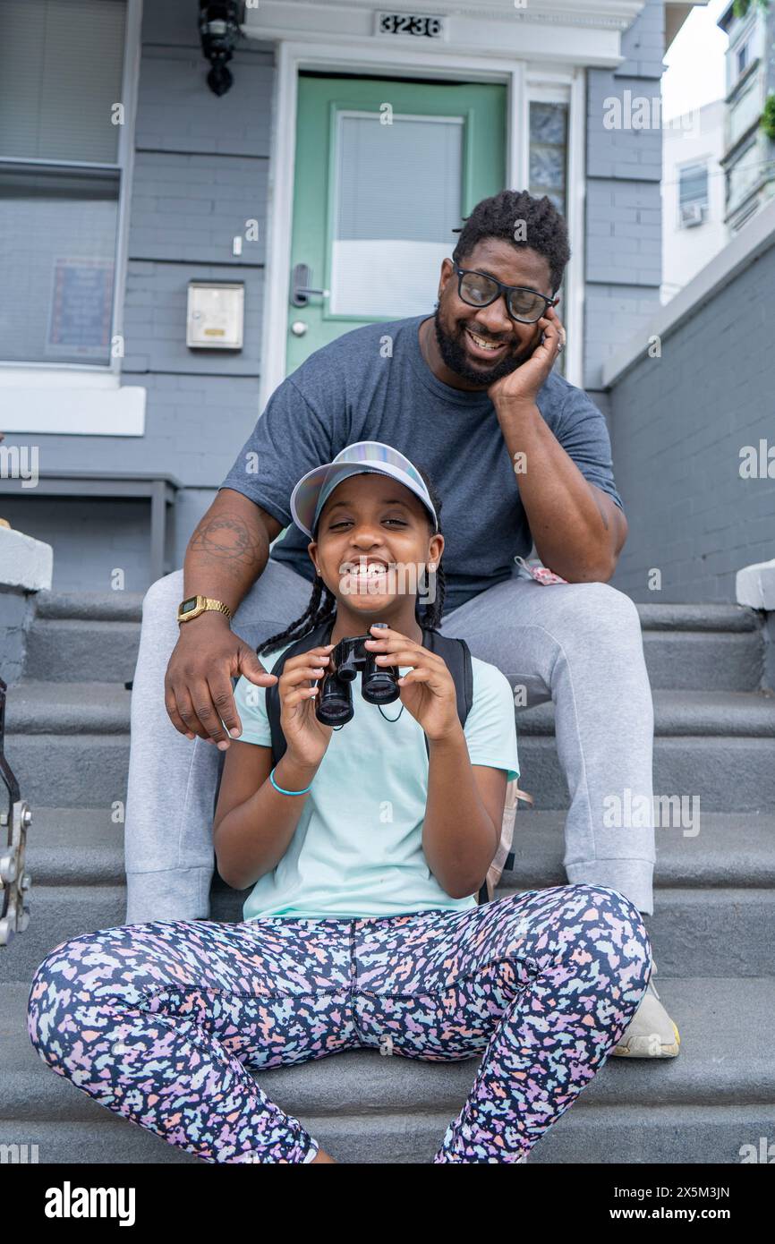Portrait of father and daughter sitting on porch Stock Photo - Alamy