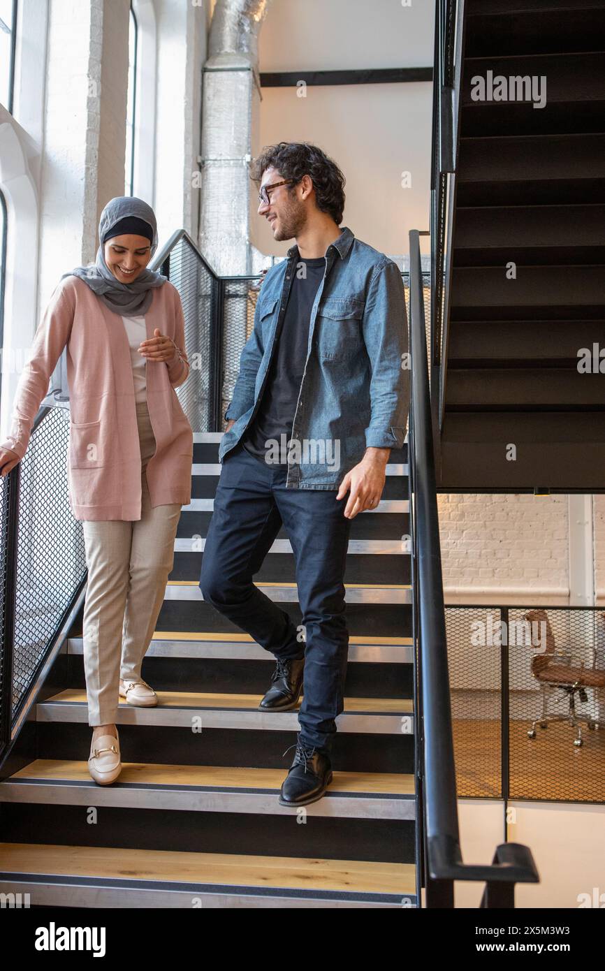 Woman wearing headscarf and man talking on steps Stock Photo - Alamy