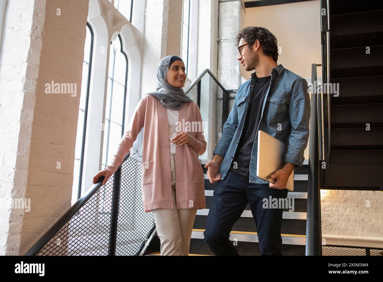 Woman wearing headscarf and man talking on steps Stock Photo - Alamy
