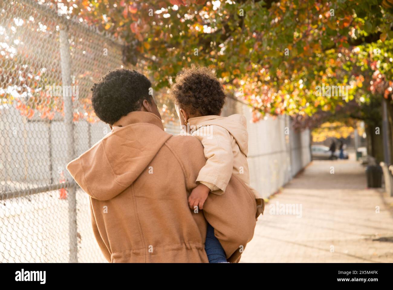 Mother carrying daughter (18-23 months) on walk Stock Photo - Alamy