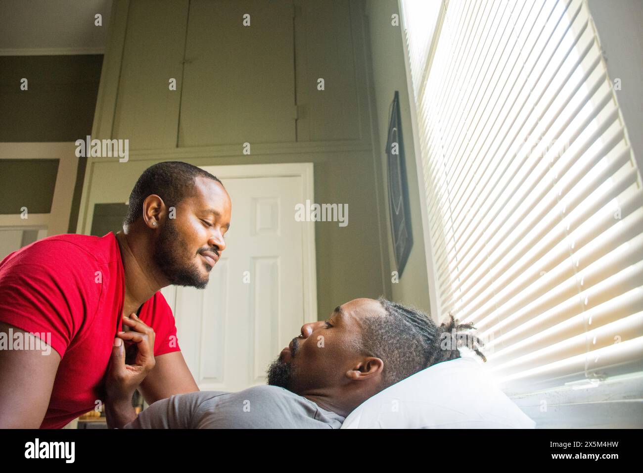 Male couple cuddling in bed Stock Photo - Alamy