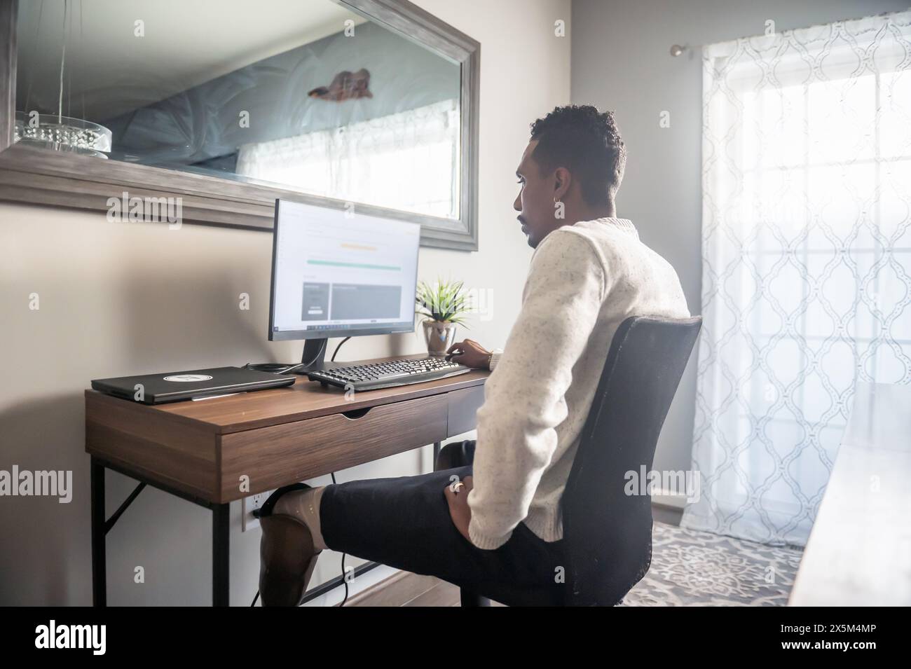 Man with prosthetic leg using computer at home Stock Photo - Alamy