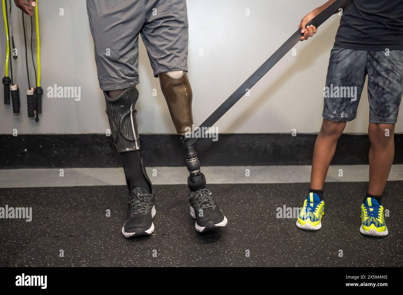 Son assisting father with prosthetic leg exercising in gym Stock Photo ...
