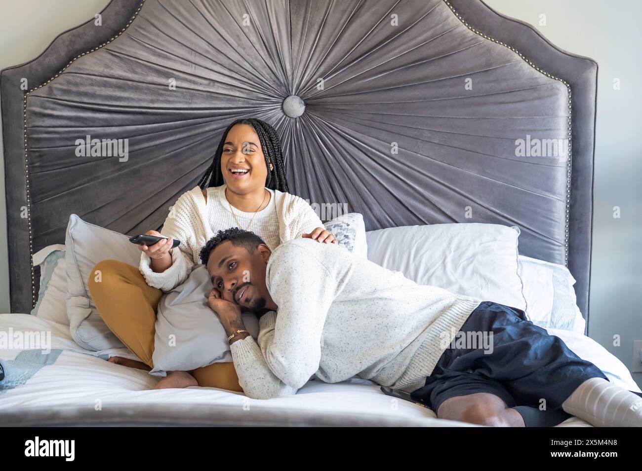 Woman and man with prosthetic leg watching TV in bedroom Stock Photo ...