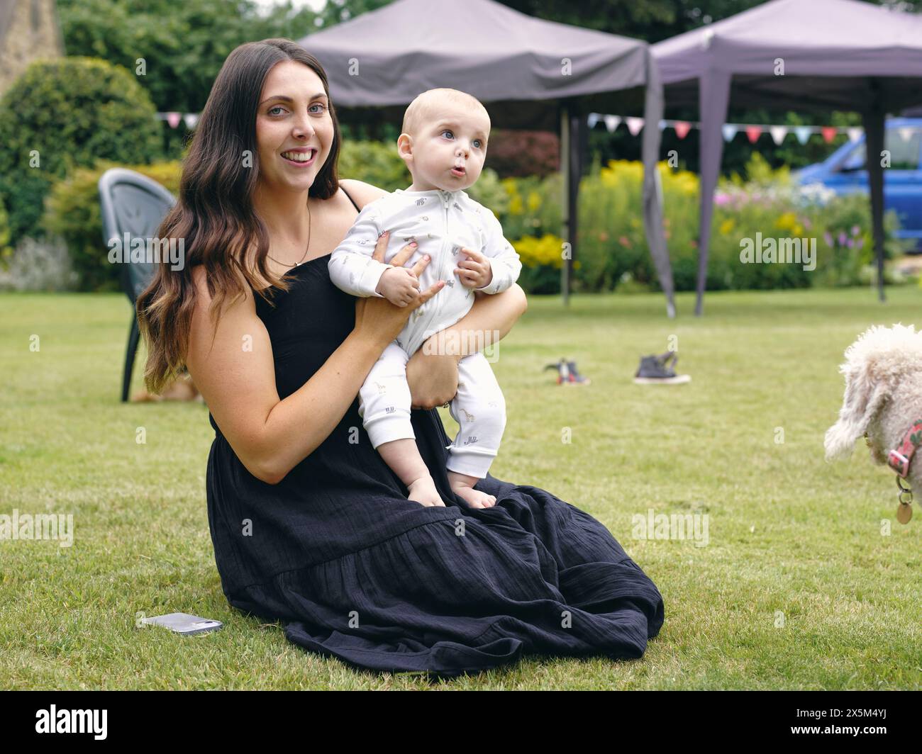 Portrait of mother holding baby son in backyard Stock Photo - Alamy