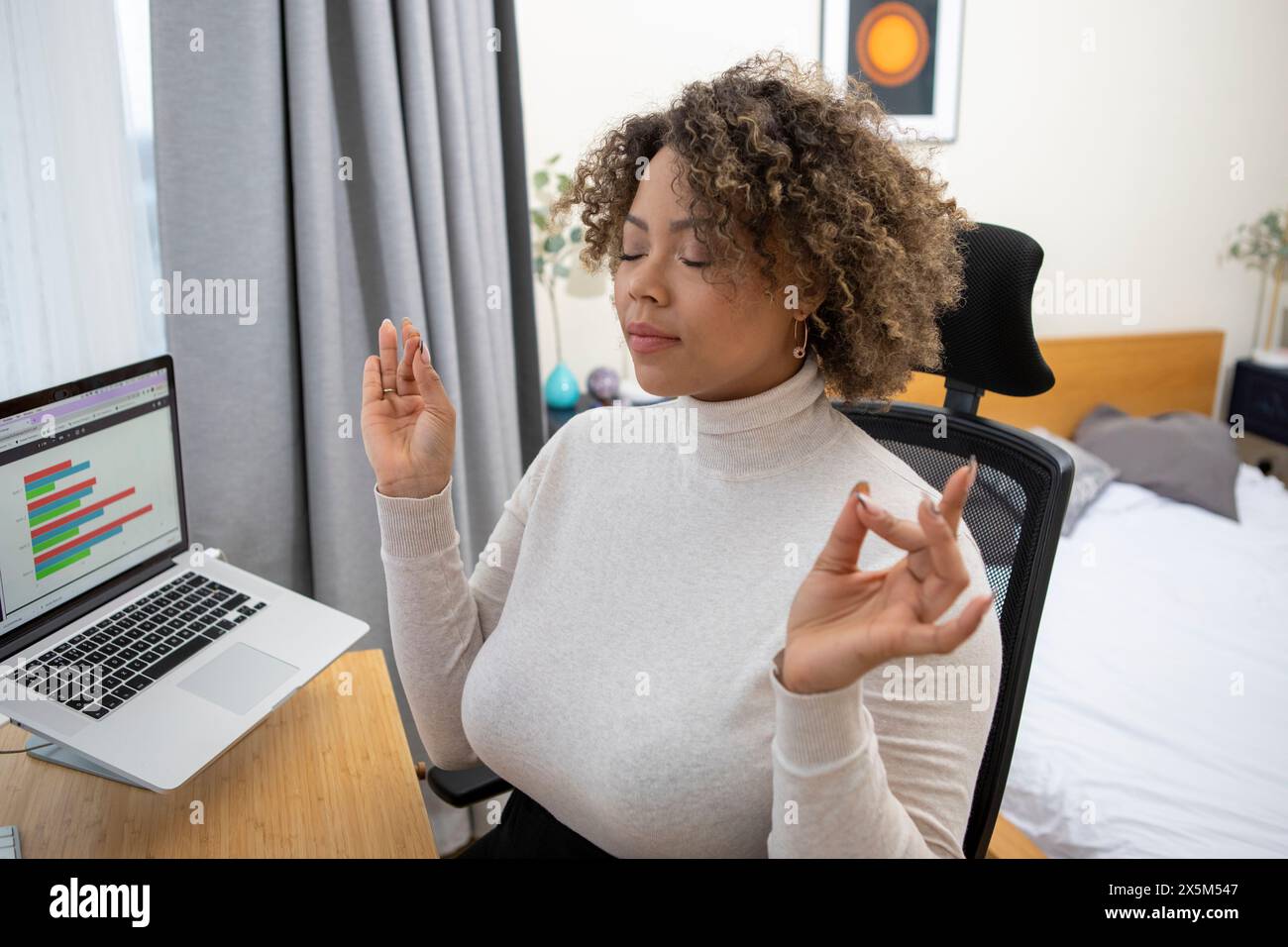 Woman meditating at desk in home office Stock Photo - Alamy