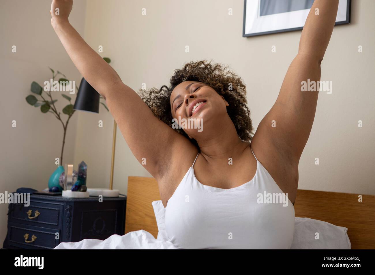 Woman waking in bedroom stretching hi-res stock photography and images ...