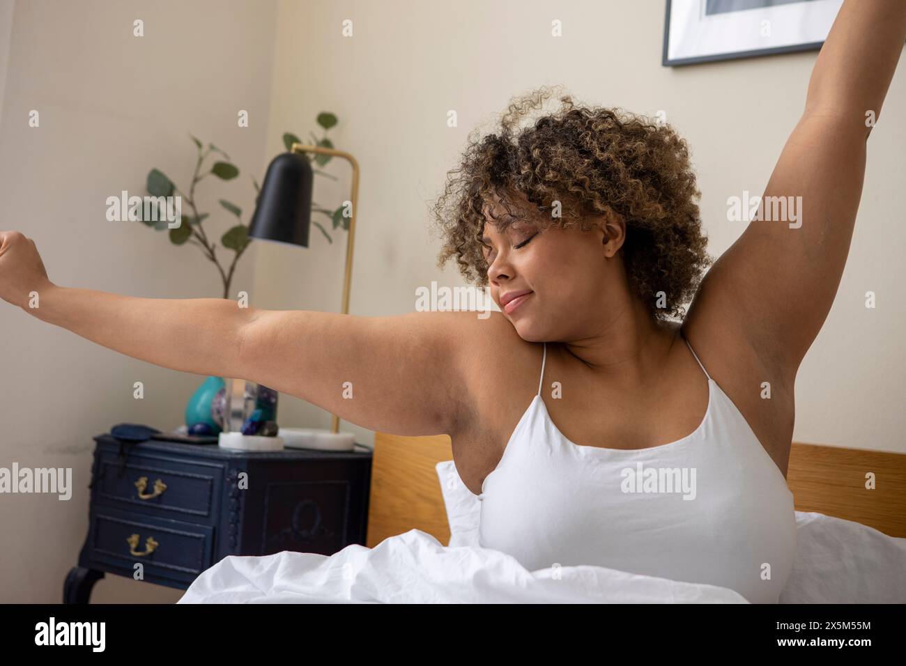 Woman stretching in bed Stock Photo - Alamy