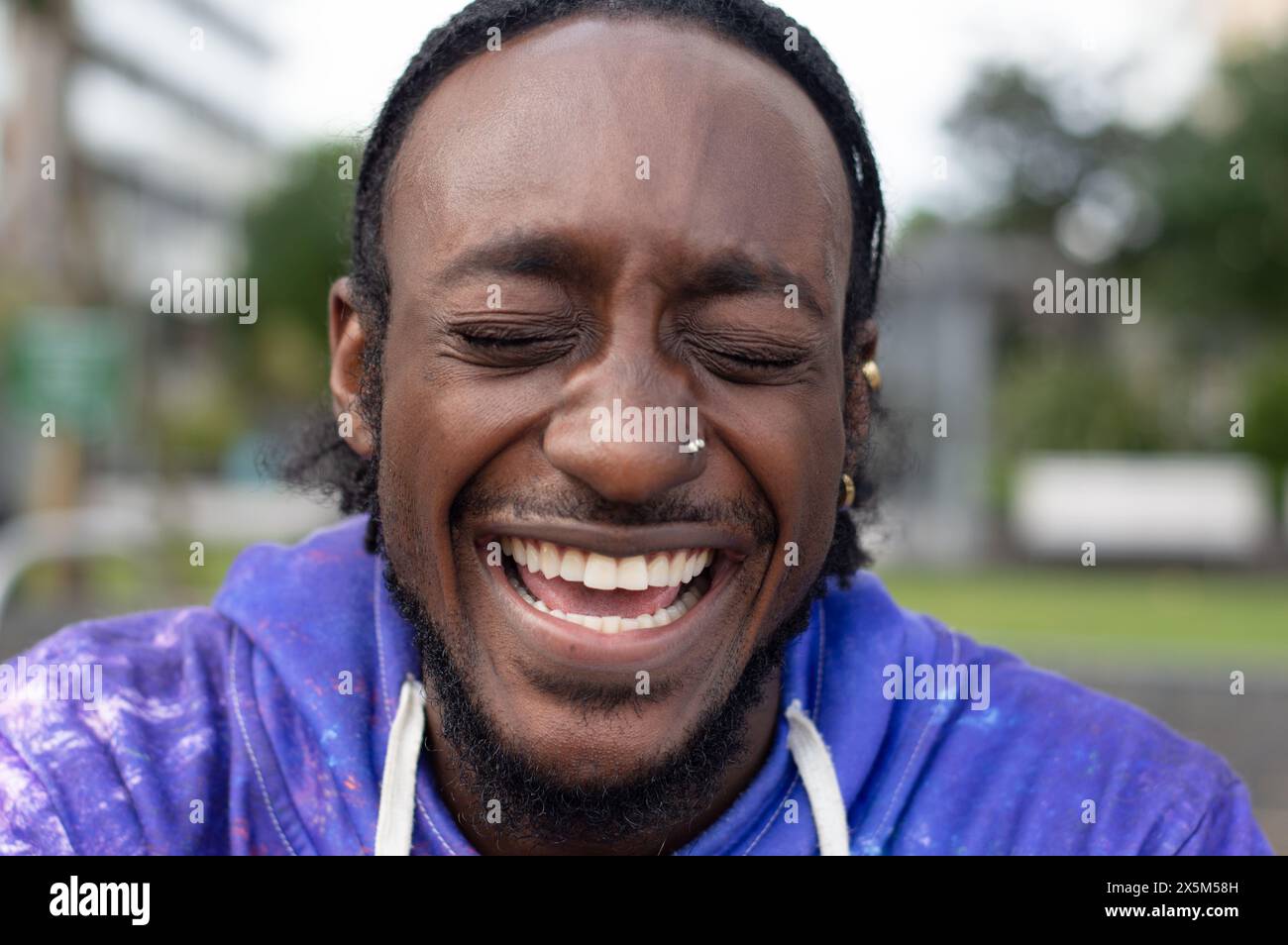 Portrait of young man laughing outdoors Stock Photo - Alamy
