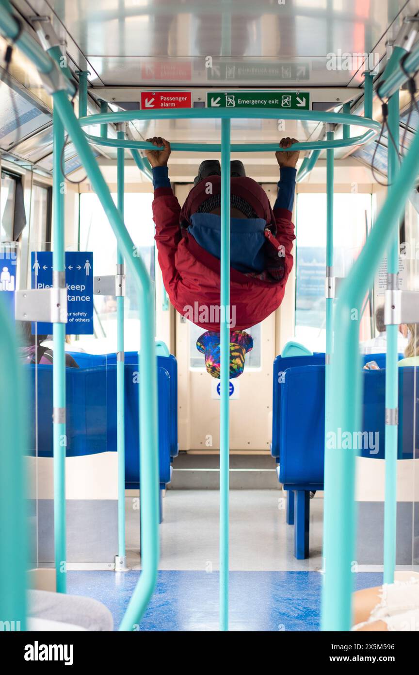 Young man hanging on railing in subway train Stock Photo - Alamy