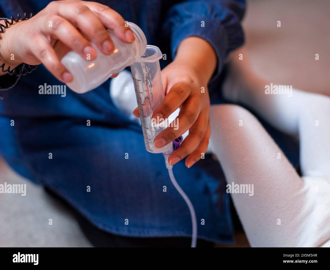 Mother pouring water into daughters feeding tube Stock Photo - Alamy