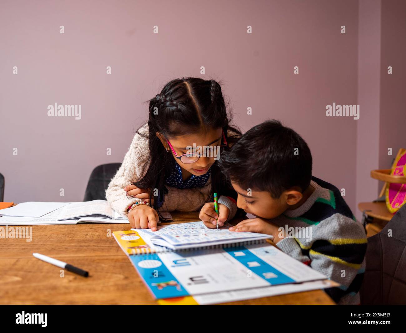 Siblings doing homework Stock Photo - Alamy